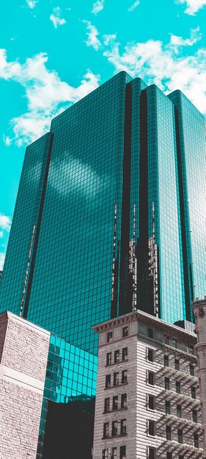 turquoise sky frames a reflective downtown office building, windows in ...
